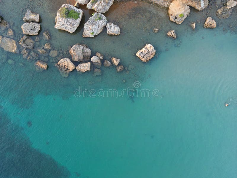 Aerial View of Bright Blue Waters with Large Rocks Standing Around the ...