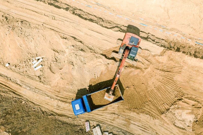 Aerial View of Excavator Moving Ground and Loading it in Dump Truck ...