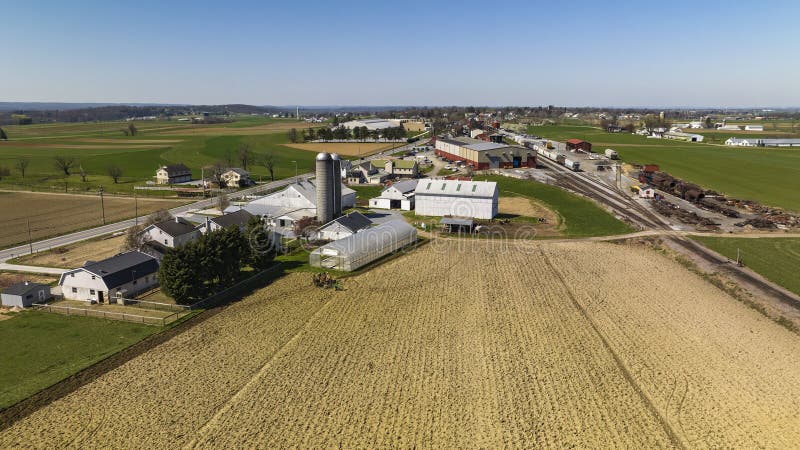 Aerial View of a Farm Complex with Multiple Barns, Silos, and Plowed ...