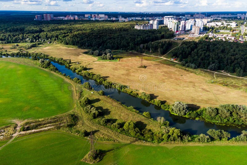 Aerial View of Fields and a River Crossed by a High-voltage Power Line ...
