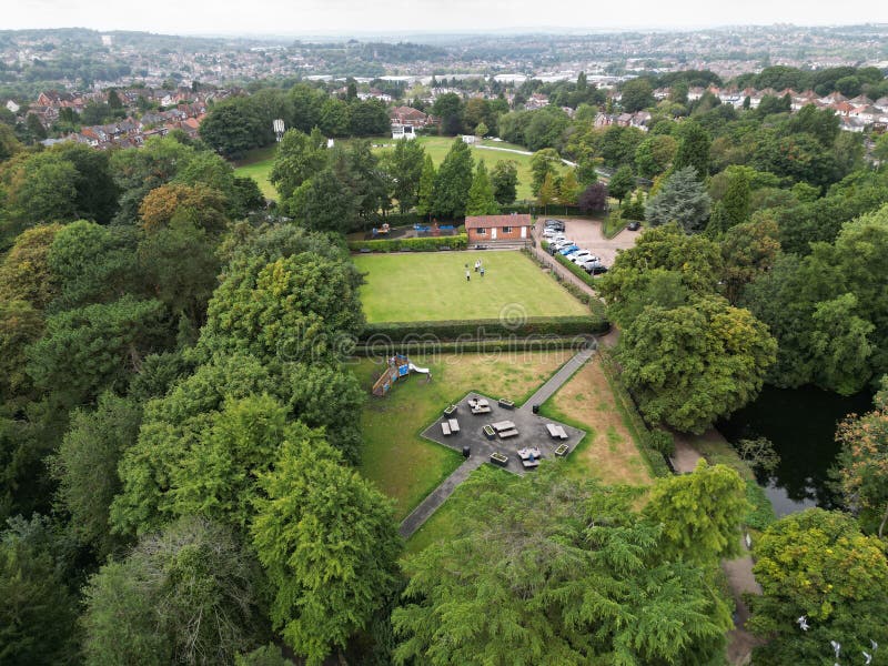 Aerial View of Greenery Field Surrounded by Dense Trees and Buildings ...