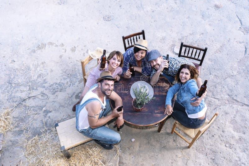 Aerial View of a Group of Friends Sitting Around a Table Holding Beers ...
