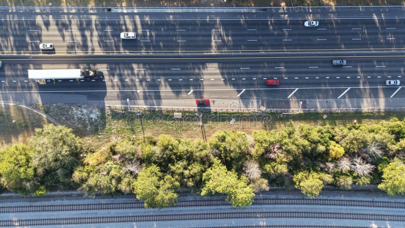View of a Highway with Vehicles and Adjacent Greenery and Train Tracks ...