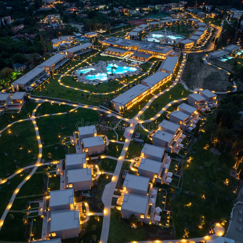 Aerial View of an Illuminated Resort Complex Featuring Pools, Paths ...