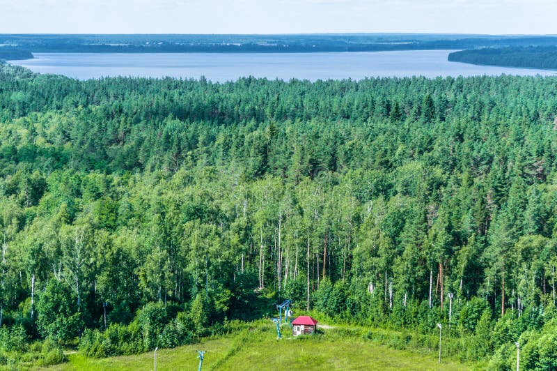 Aerial View of Mixed Forest and Distant River and Small House at Bottom ...