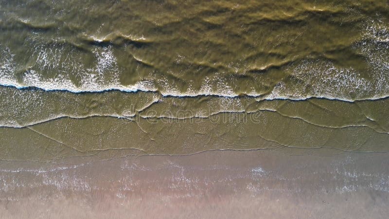 Aerial View of Ocean Waves Gently Rolling Onto a Sandy Beach, Creating Natural Patterns and ...