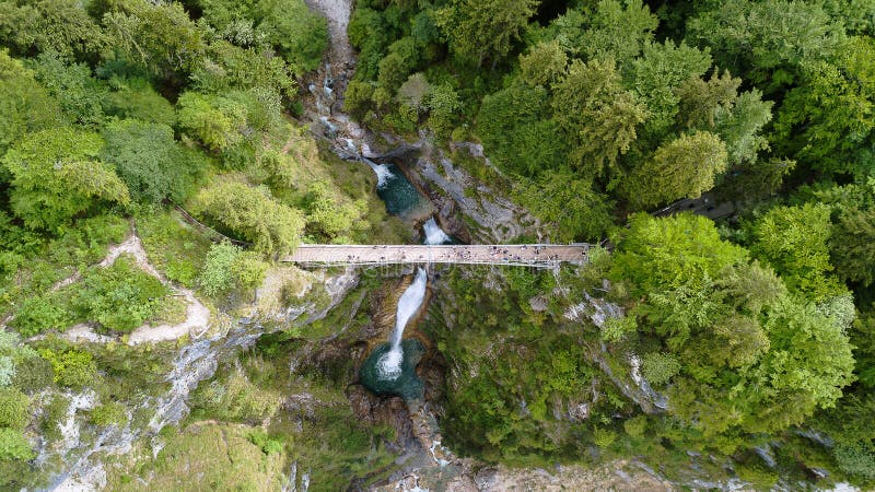Aerial View of a Pedestrian Bridge through a Gorge with a Waterfall ...