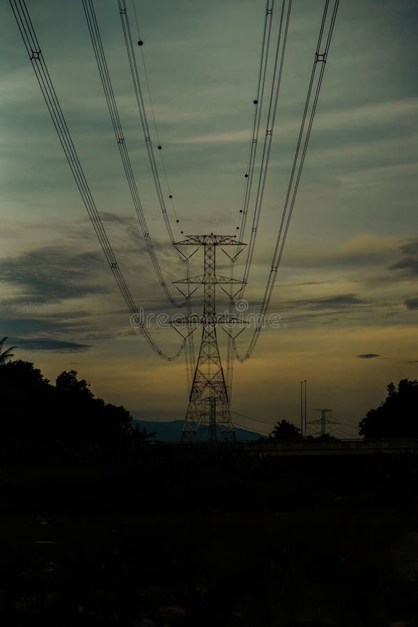 Aerial View of a Power Line Illuminated at Dusk, Surrounded by a Vast ...