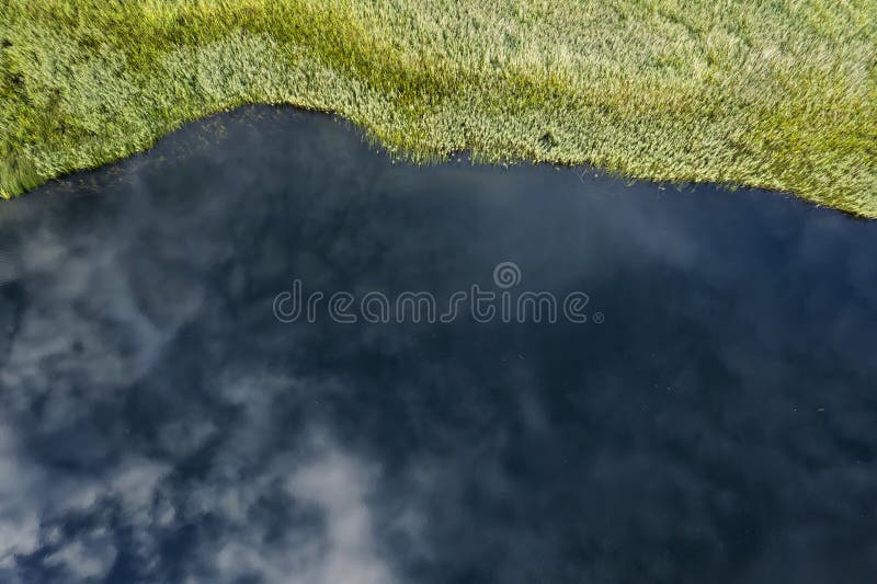 Aerial View on a River Bank with Green Grass Field and Cloudy Sky ...