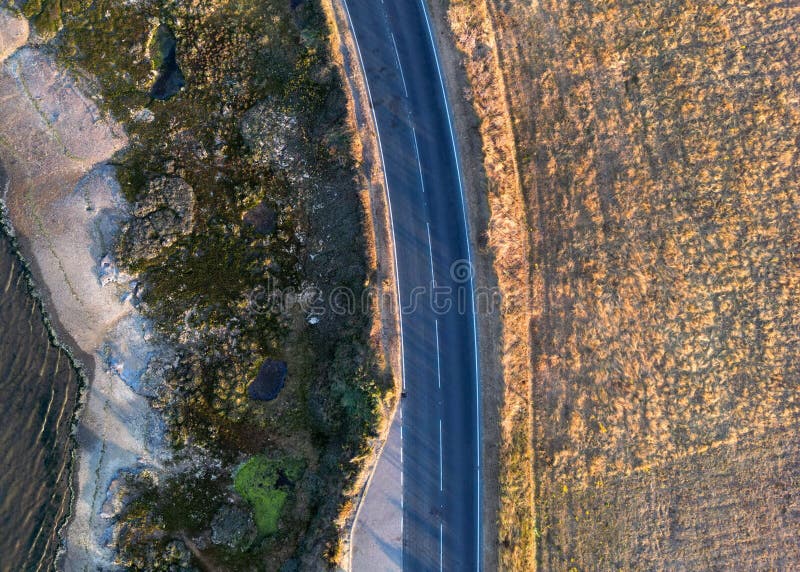 Aerial View of a Road Has Rough Landscape from a Side and Beach from ...