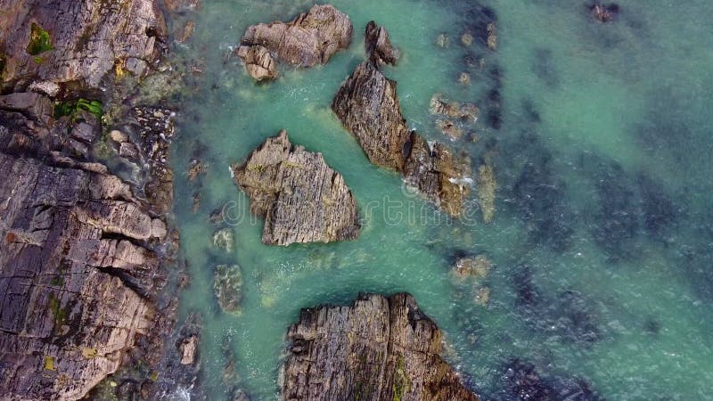An Aerial View of a Rocky Shoreline with a Gradient of Colors in the ...