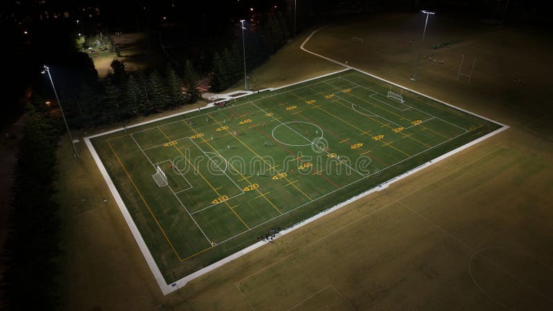 Aerial View of a Rugby Field Surrounded by Bright Lights in the Evening ...