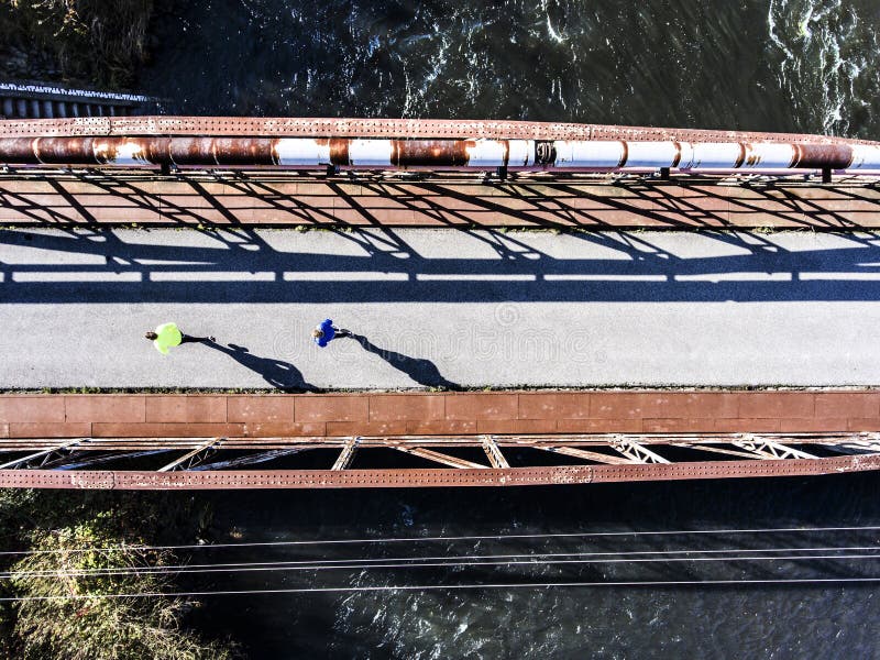 Aerial View of a Runner Running Across Bridge Over the River. Morning ...