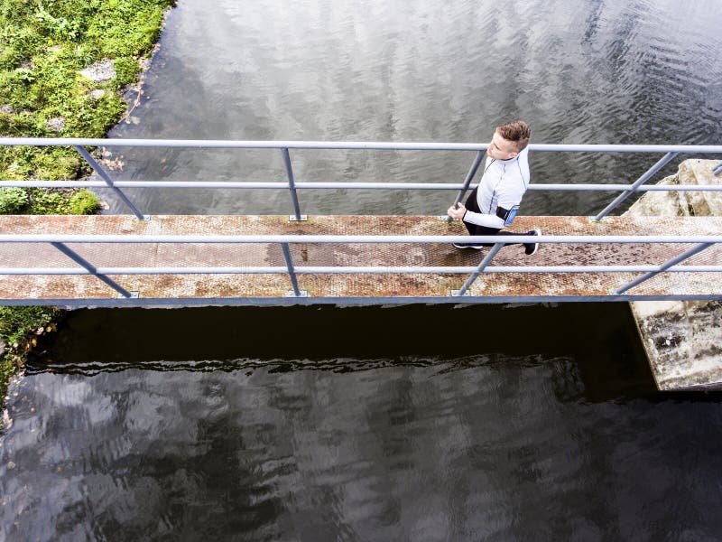 Aerial View of a Runner Running Across Bridge in Park on a Jogging Path ...