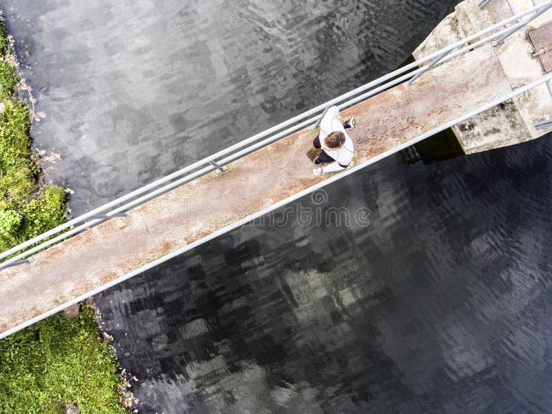 Aerial View of a Runner Running Across Bridge in Park on a Jogging Path ...