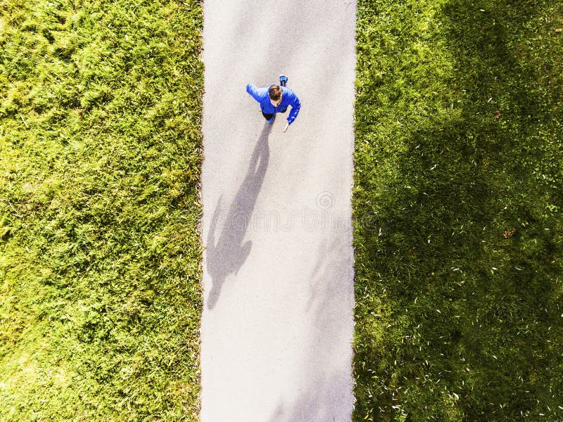 Aerial View of a Runner Running through Autumn Park on Jogging Path ...