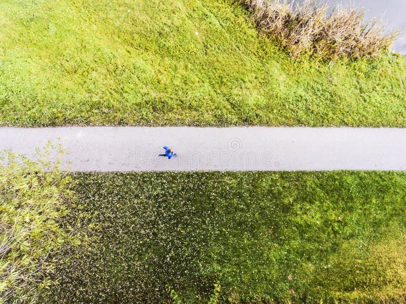 Aerial View of a Runner Running through Autumn Park on Jogging Path ...