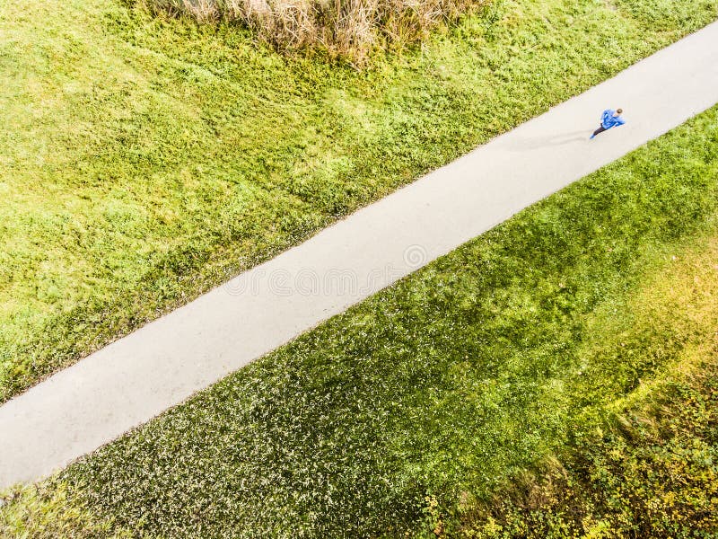 Aerial View of a Runner Running through Autumn Park on Jogging Path ...