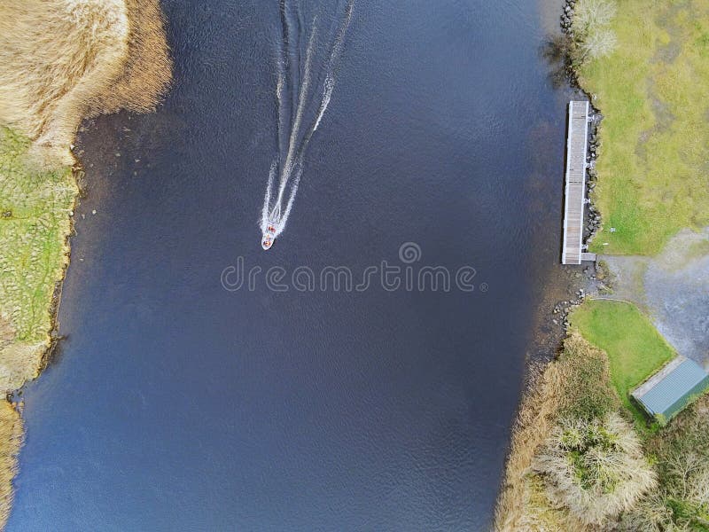 Aerial View on a Small Boat Moving in a River by a Small Pier and ...