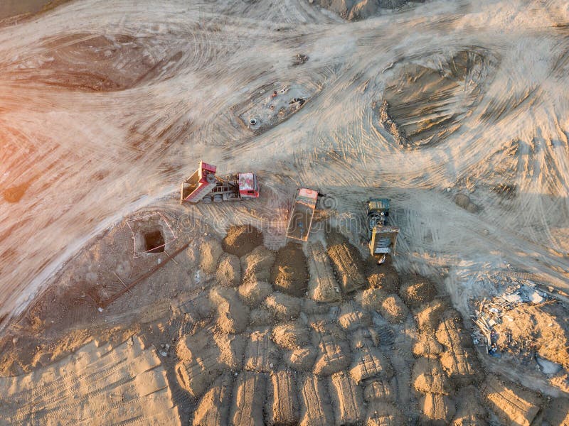 Aerial View of Three Multi-colored Dump Tip Trucks Unloading in Stock ...
