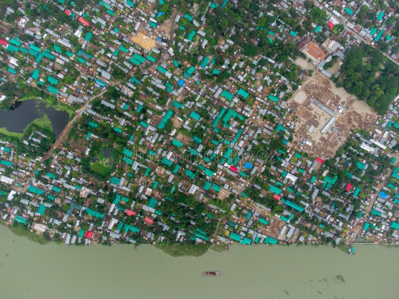 Aerial View of a Town on the Riverside with a Single Boat in the Water ...
