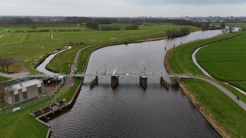 Aerial View of a Tranquil River with Open Drawbridge, Surrounded by ...