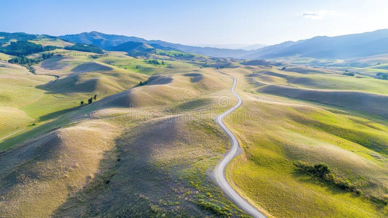 Aerial View of a Winding Road through Rolling Hills and Green Fields ...