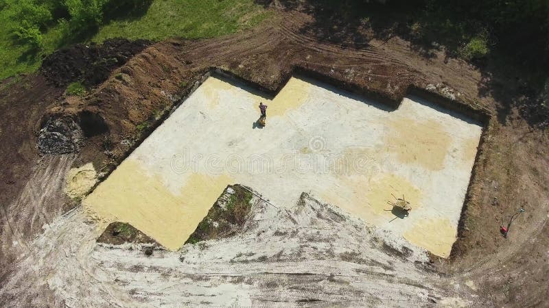 Aerial of Worker with Vibratory Plate Compactor Ramming Sand in ...