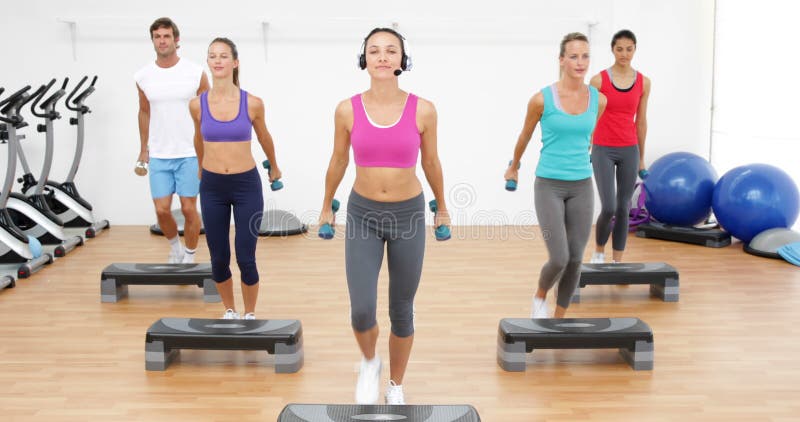 Aerobics Class Stepping Together Led by Instructor and Lifting ...