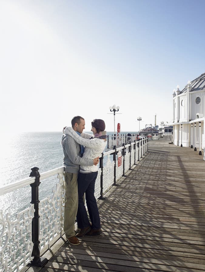 Affectionate Couple by the Sea on Pier Stock Photo - Image of lifestyle ...