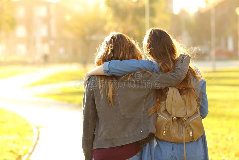 Affectionate Friends Walking at Sunset in a Park Stock Image - Image of ...