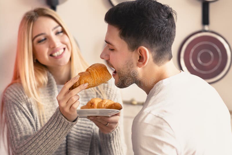 Affectionate Young Couple Sharing Breakfast Together in Kitchen Stock ...