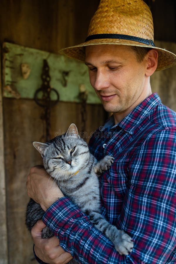 Affectionate Young Male Farmer Petting Cat in Barn. Stock Photo - Image ...