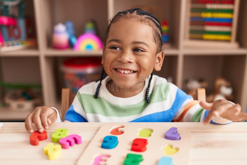 African American Boy Playing with Maths Puzzle Game Sitting on Table at ...