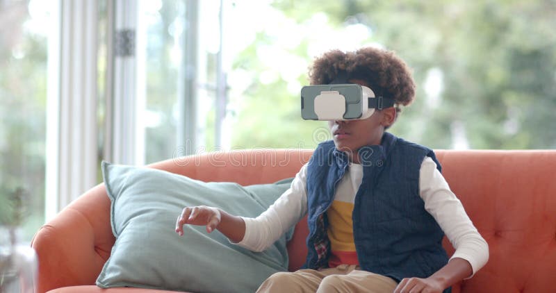 African American Boy Sitting on Sofa, Using Vr Headset and Touching ...