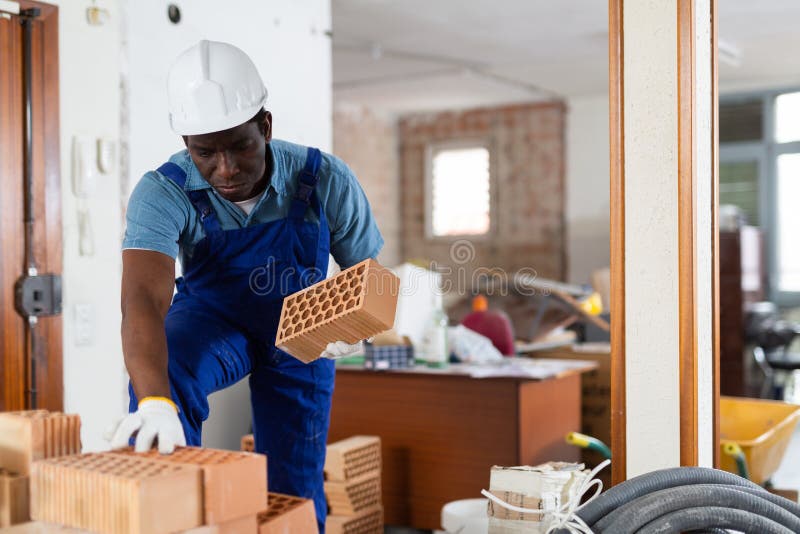 African American Builder Stacking Bricks in Building Under Renovation ...