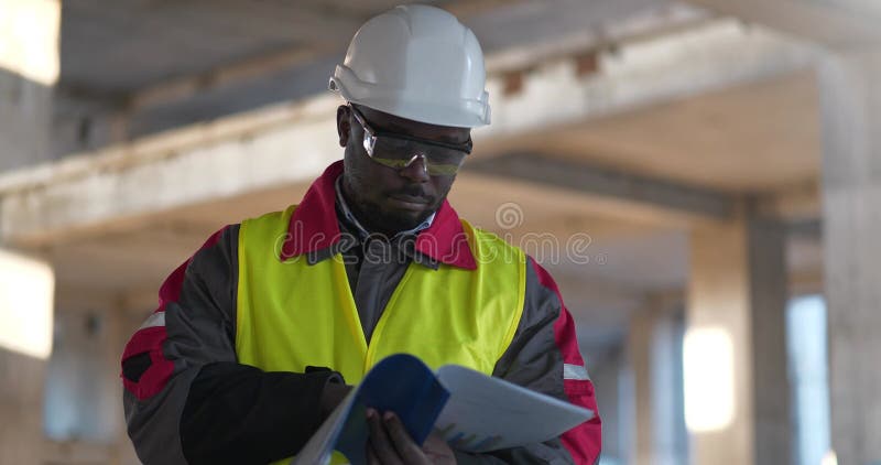 African American Builder Stands at Construction Site, Looks in Work ...