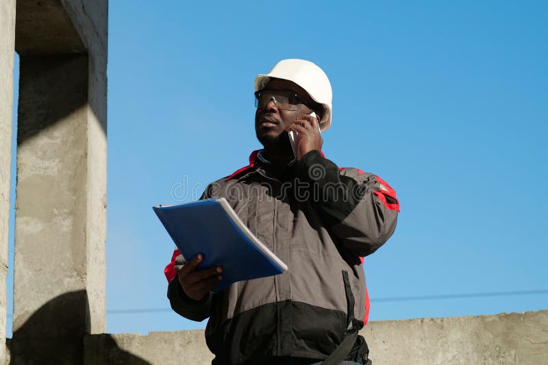 African American Builder with Work Papers Talks on Smartphone Stock ...