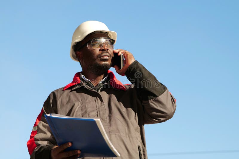 African American Workman with Smartphone at Construction Site Stock ...