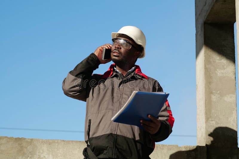 African American Builder with Work Papers Talks on Smartphone Stock ...