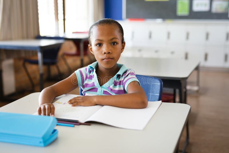 African American Child Studying at Desk in Elementary Classroom, with ...