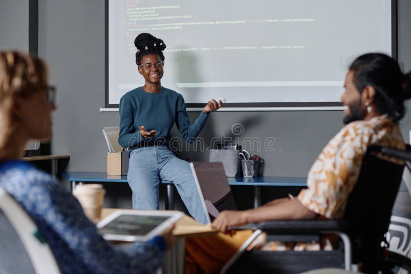 African American Coder Interacting with Colleagues while Showing ...