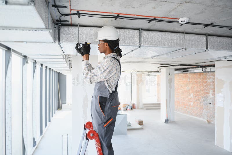 Construction Worker Installing Ventilation System in Building Under ...