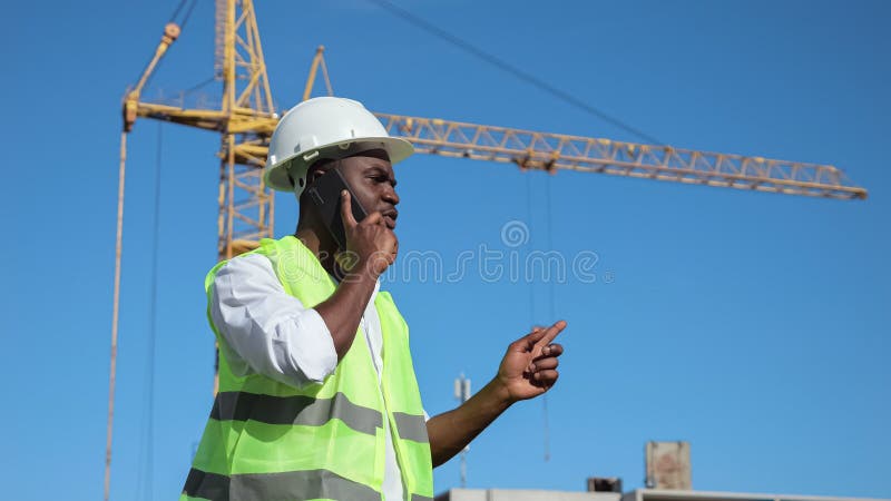 African American Constructor Talks on Phone with Team Member Stock ...