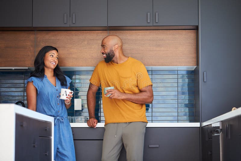 African American Couple Talking and Drinking Coffee in Kitchen at Home ...