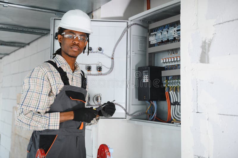 African, American Electrician Connecting Cables in Fuse Box at ...