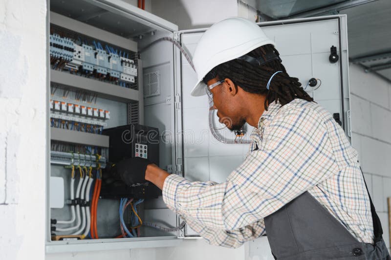 African, American Electrician Installing Ventilation System Control Panel in Building Stock ...