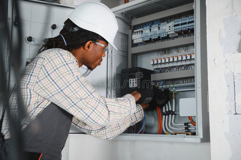 African, American Electrician Working on Control Panel in Building ...
