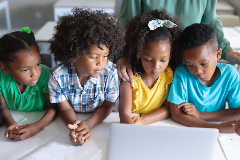 African American Elementary Students Looking in Laptop while Sitting at ...