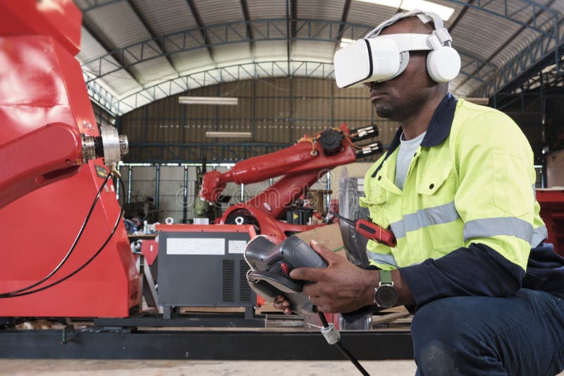 Black Engineer with VR Glasses Controls Robotic Arm in Manufacturing ...